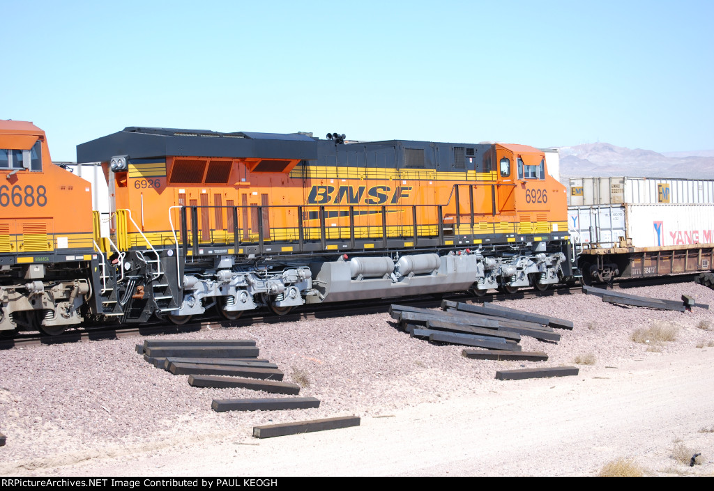 BNSF 6926 and the cab nose of BNSF 6688 pass me by as they head eastbound as Rear DPU's.